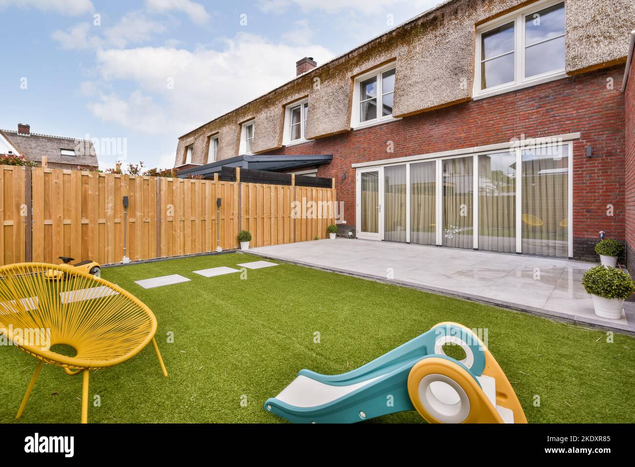 Residential brick building with glass doors located on tiled terrace ...