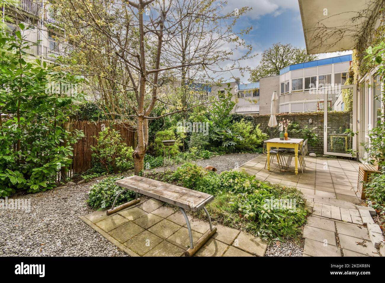 Terrace of residential building with table and chairs placed near green ...