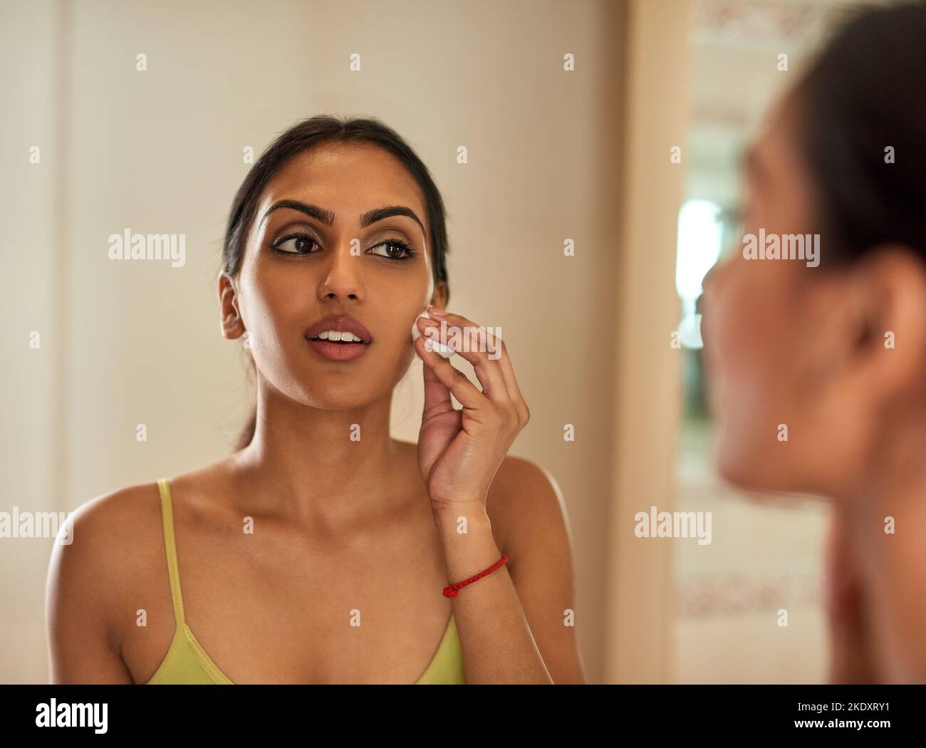 Ensuring her skin stays vibrant and youthful. a young woman cleaning ...