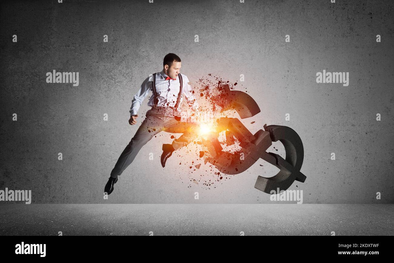 Determined banker man in empty concrete room breaking dollar figure ...