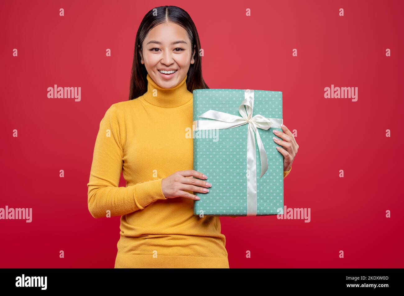 Happy young woman showing off her present Stock Photo - Alamy