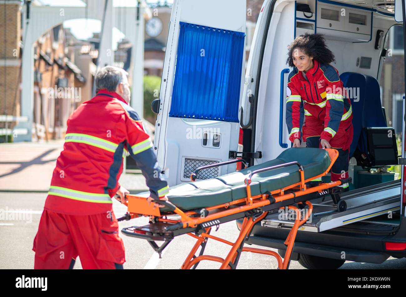 Paramedical workers taking a stretcher out of the EMS vehicle Stock ...