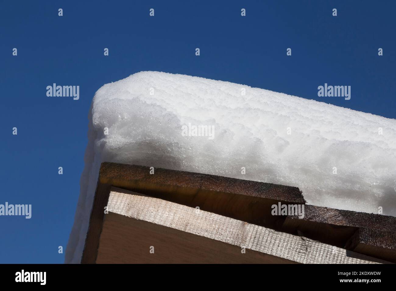 view on snowdrift on roof of shed against blue sky Stock Photo - Alamy