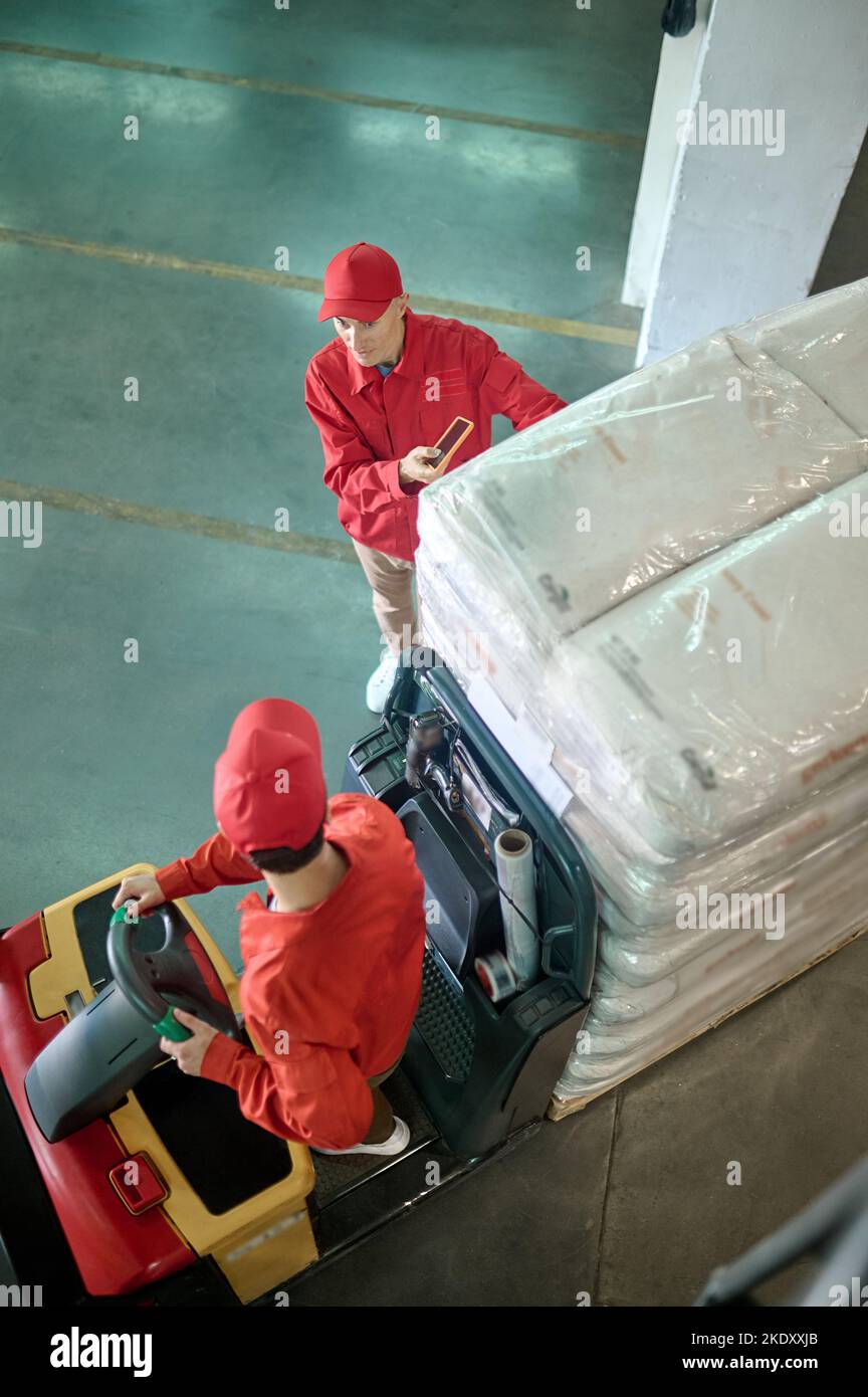 Two experienced warehouse workers discussing freight transportation ...