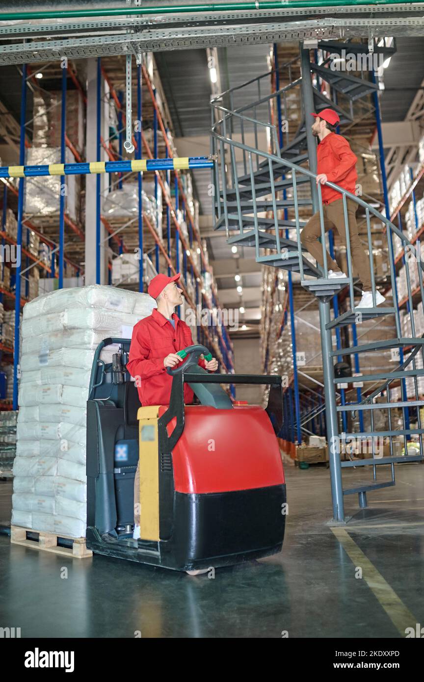 Forklift driver and his coworker in the storage area Stock Photo - Alamy