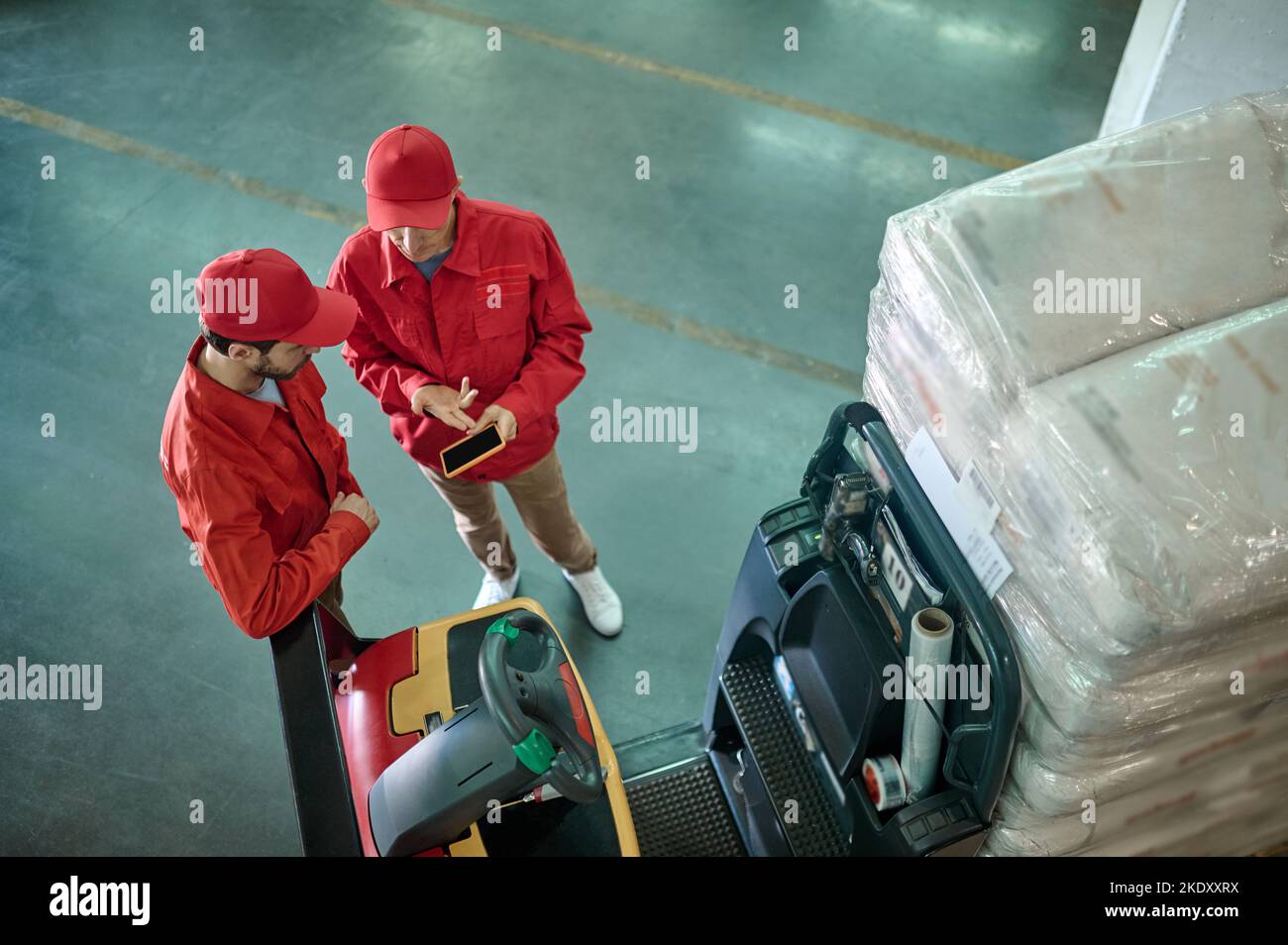 Warehouse supervisor and a forklift operator discussing cargo delivery ...