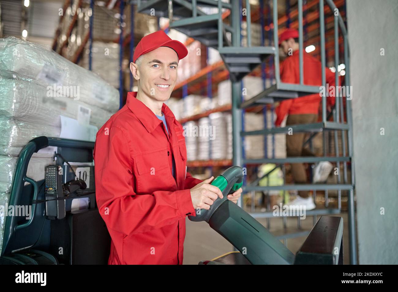 Cheerful lift truck operator and his colleague in the warehouse Stock ...