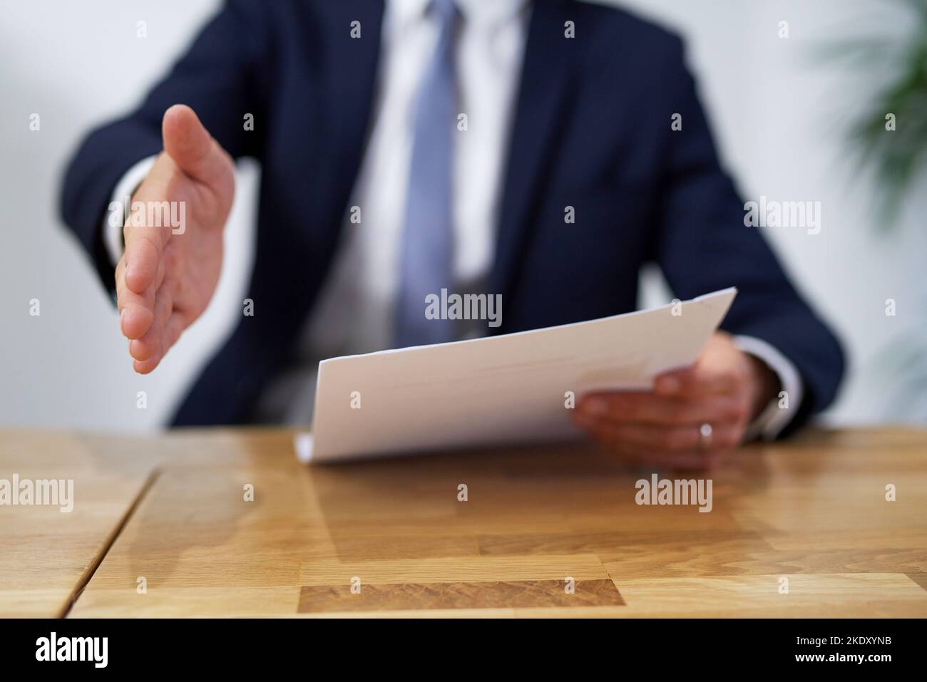 Youve got the job. a businessman sitting at a desk and holding ...