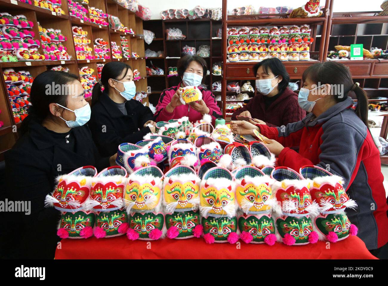Craftsmen are discussing the skills of sewing tiger-head shoes in ...