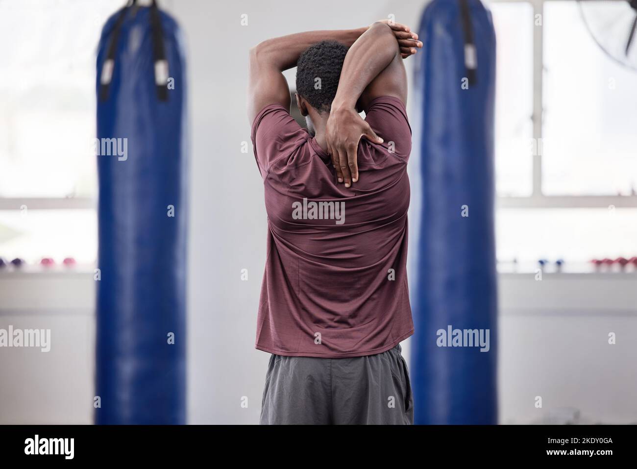 Boxer stretch, black man and athlete at a gym stretching arms before ...