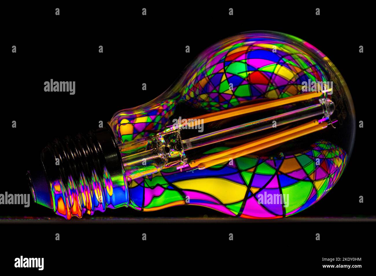 A Light Bulb on a black background with a bright pattern reflection ...