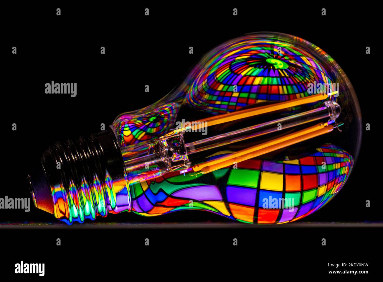 A Light Bulb on a black background with a bright pattern reflection ...