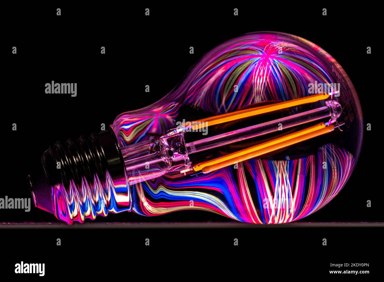 A Light Bulb on a black background with a bright pattern reflection ...