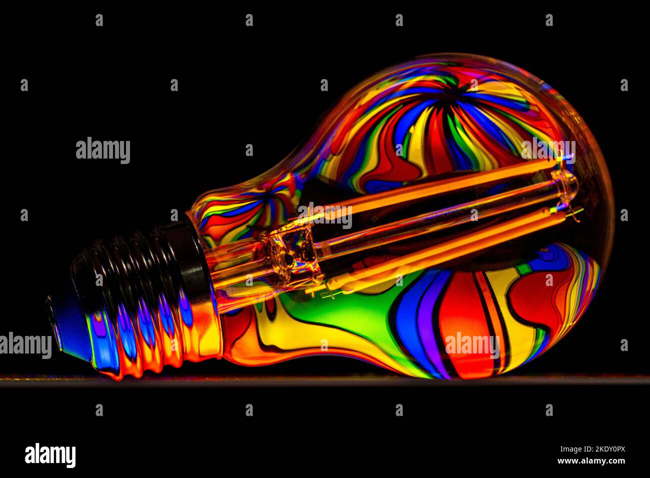 A Light Bulb on a black background with a bright pattern reflection ...