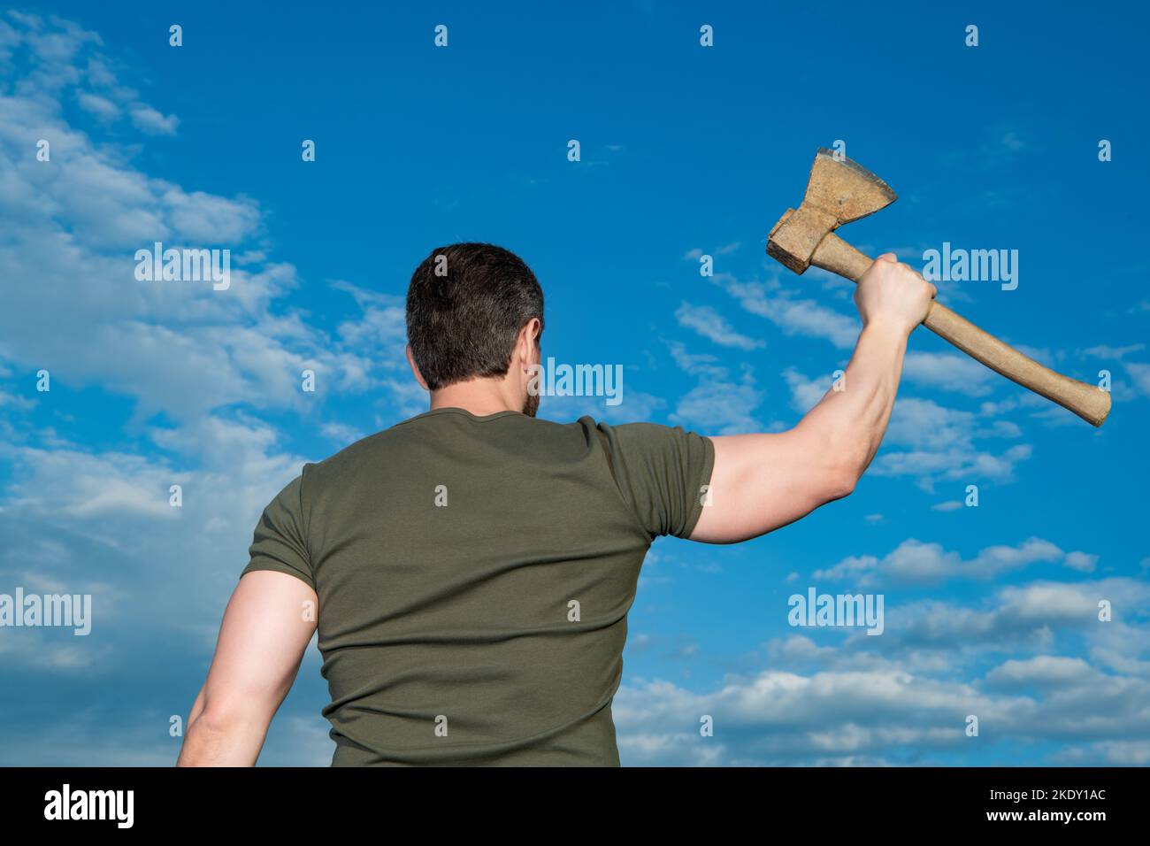 back view of man with axe. man hold ax. brutal man on sky background ...