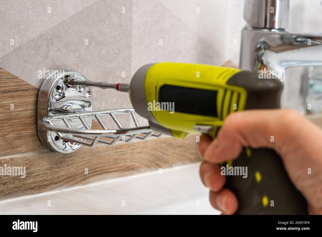cordless screwdriver that wraps a screw into a hole in a ceramic tile ...