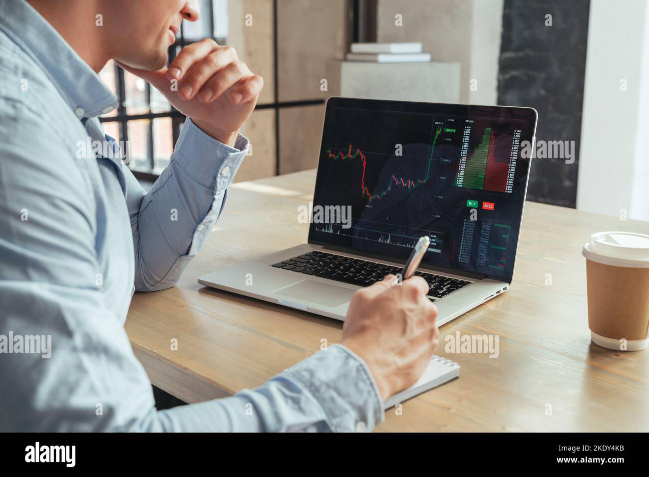 Closeup image of busy crypto analyst in front of laptop with diagram on ...