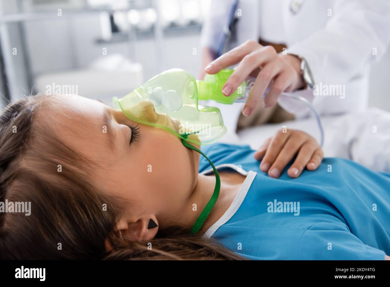 Blurred pediatrician holding oxygen mask near sick child in hospital ...