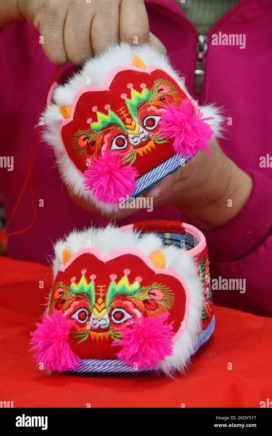 HANDAN, CHINA - NOVEMBER 7, 2022 - A craftsman sews tiger-head shoes at ...