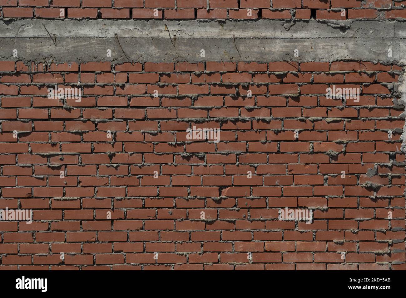 Weathered red brick wall with rough worn concrete, background Stock ...