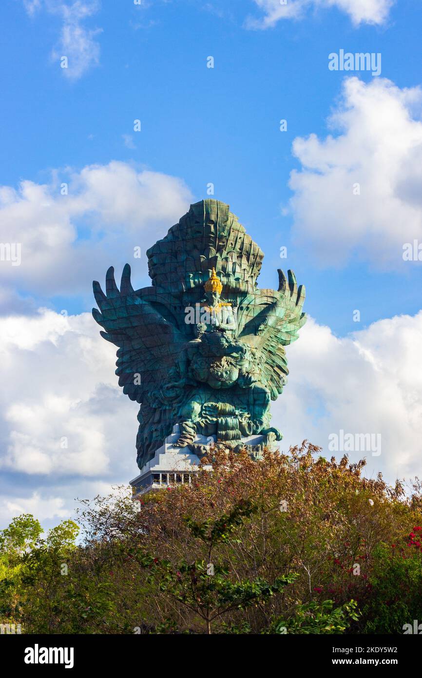 A Garuda Wisnu Kencana in Bali on a tree with clouds all over in a ...