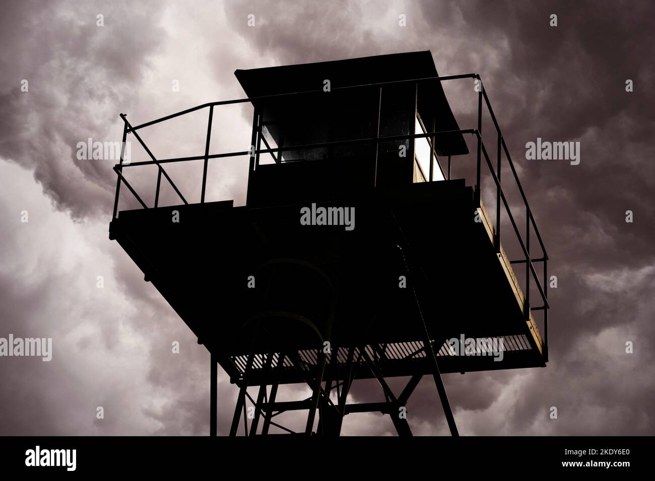 Dark silhouette of the metal structure of the watchtower, clouds in the ...