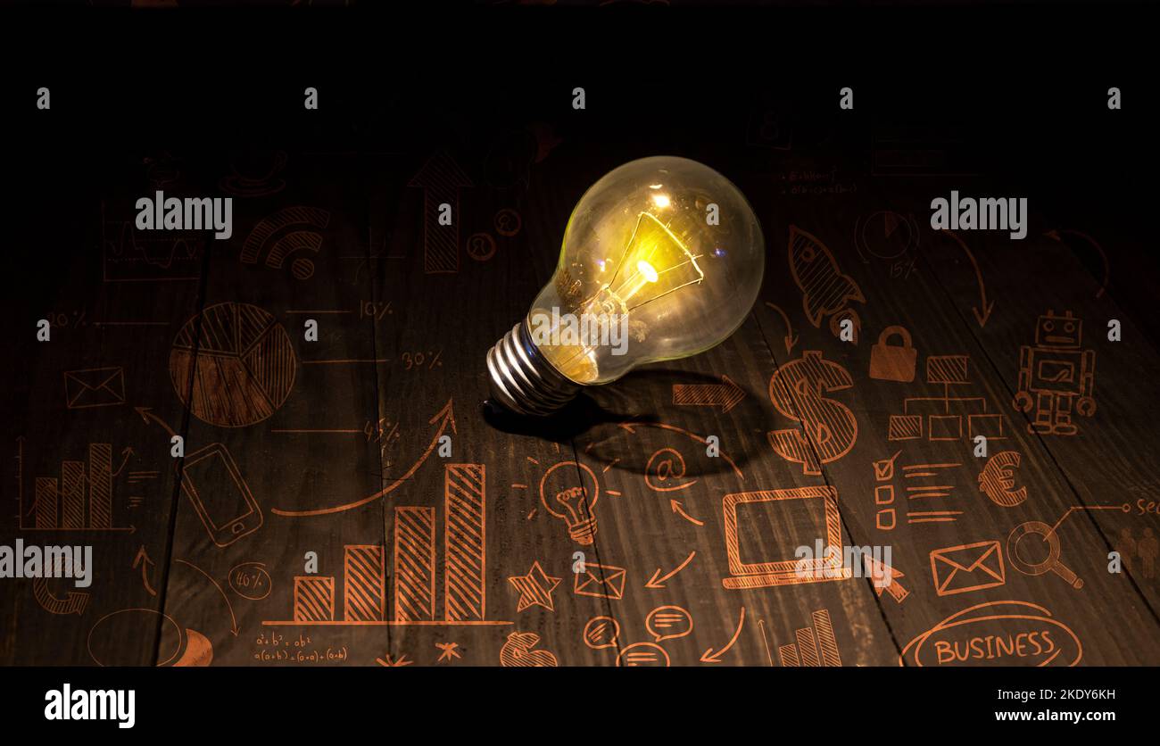Startup idea doddle icons with light bulb on wooden table Stock Photo ...
