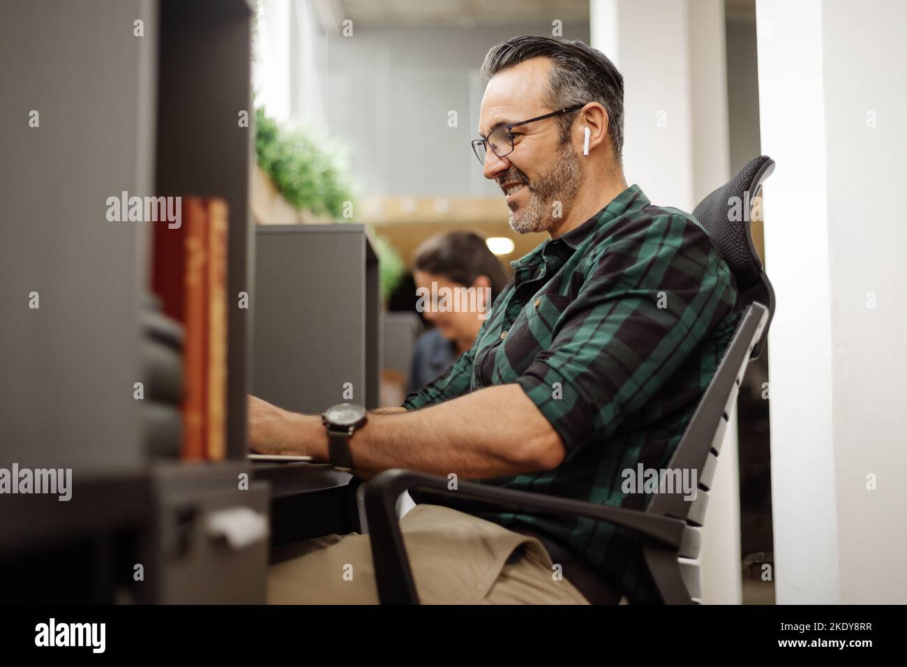Business man sitting at private hot desk at co working office workspace ...