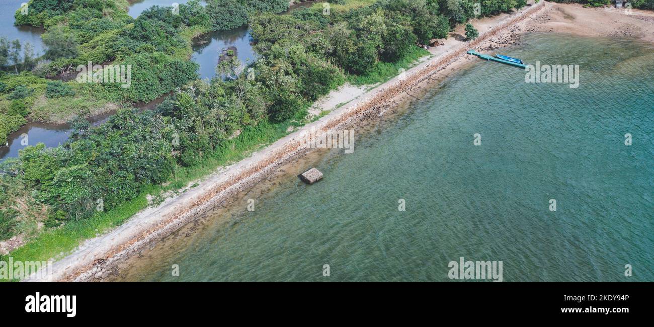 An aerial view of the seashore surrounded by trees in Lai Chi Chong ...