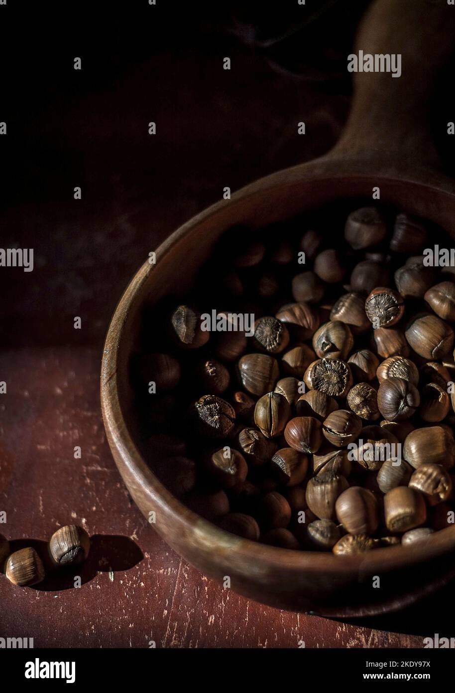 A beautiful shot of roasted chestnuts served in wooden iron vintage pan ...