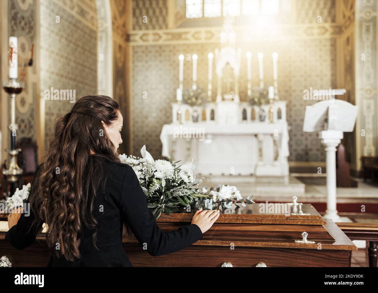Funeral coffin, death and woman in church after the loss of family ...