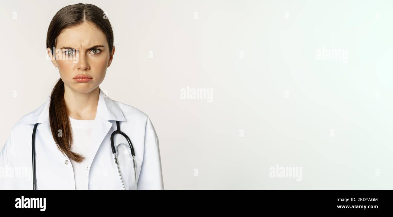 Angry and upset young woman doctor, female healthcare worker sulking ...