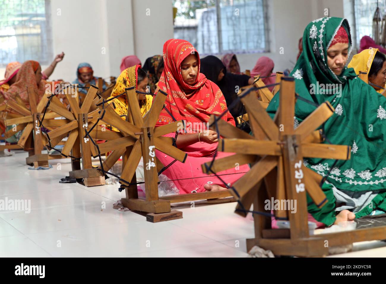 Workers spins thread from cotton to make traditional muslin garments at ...