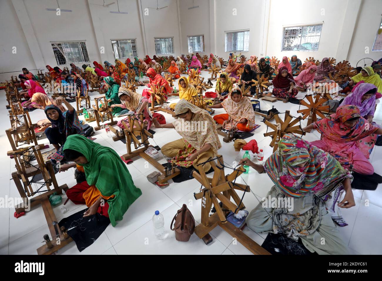 Workers spins thread from cotton to make traditional muslin garments at ...