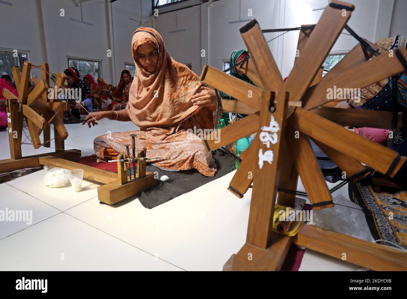 Workers spins thread from cotton to make traditional muslin garments at ...