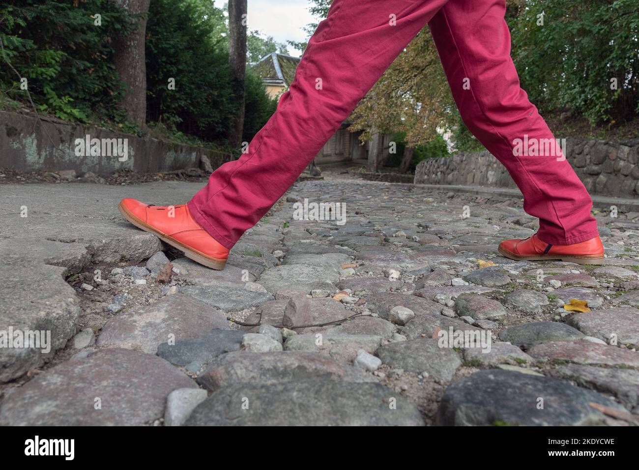 Legs in red on cobblestone street Stock Photo - Alamy