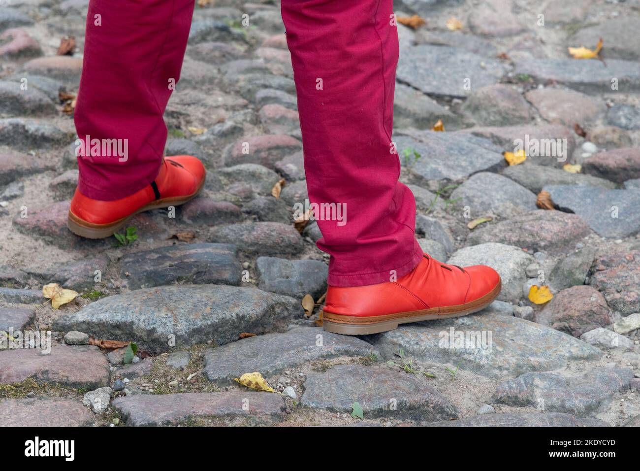 Legs in red on cobblestone street Stock Photo - Alamy