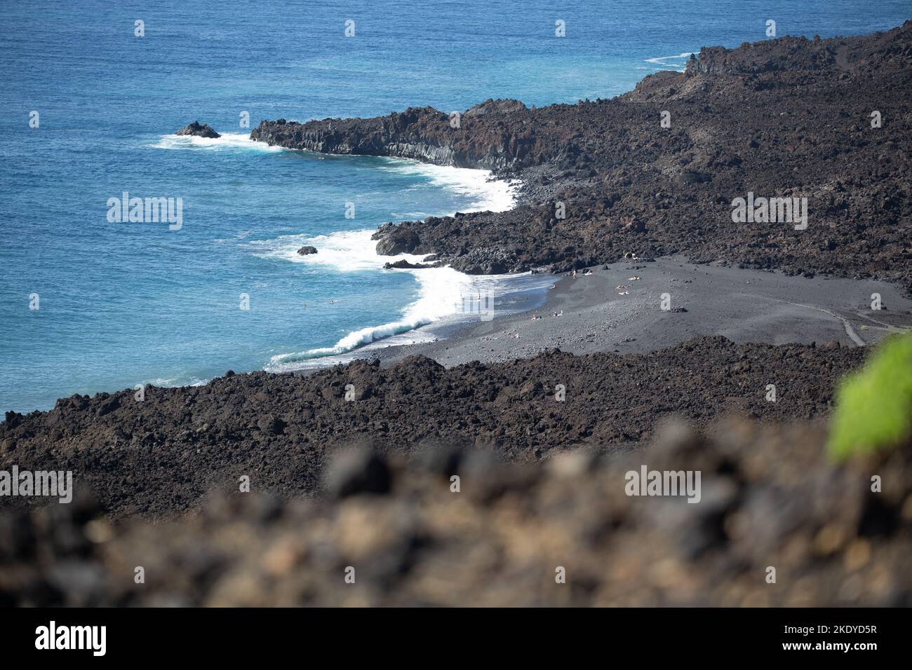 A shot of waves washing the gray sand beach surrounded by soil Stock ...
