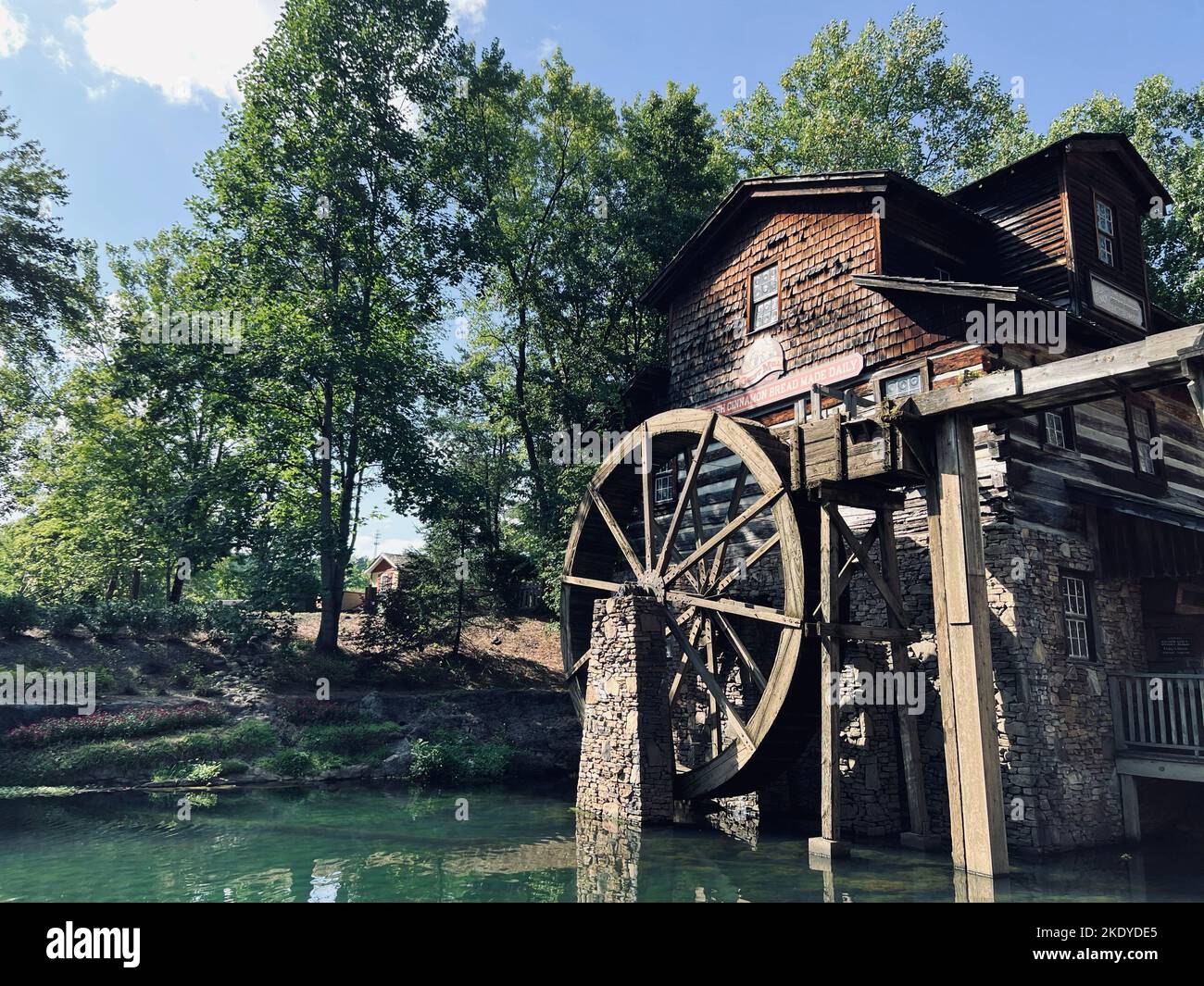 An old gristmill and a bakery surrounded by water and greenery at Dollywood, Pigeon Forge ...