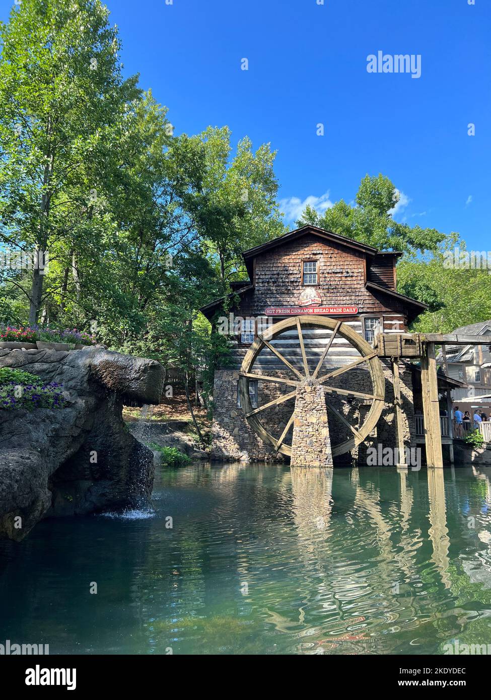 An old gristmill and a bakery surrounded by water and greenery at Dollywood, Pigeon Forge ...