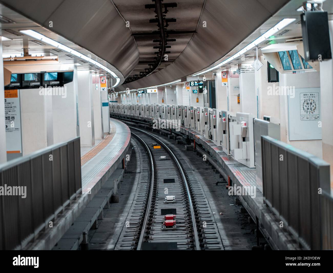 A modern Subway station in Japan with the rails and advertisement ...