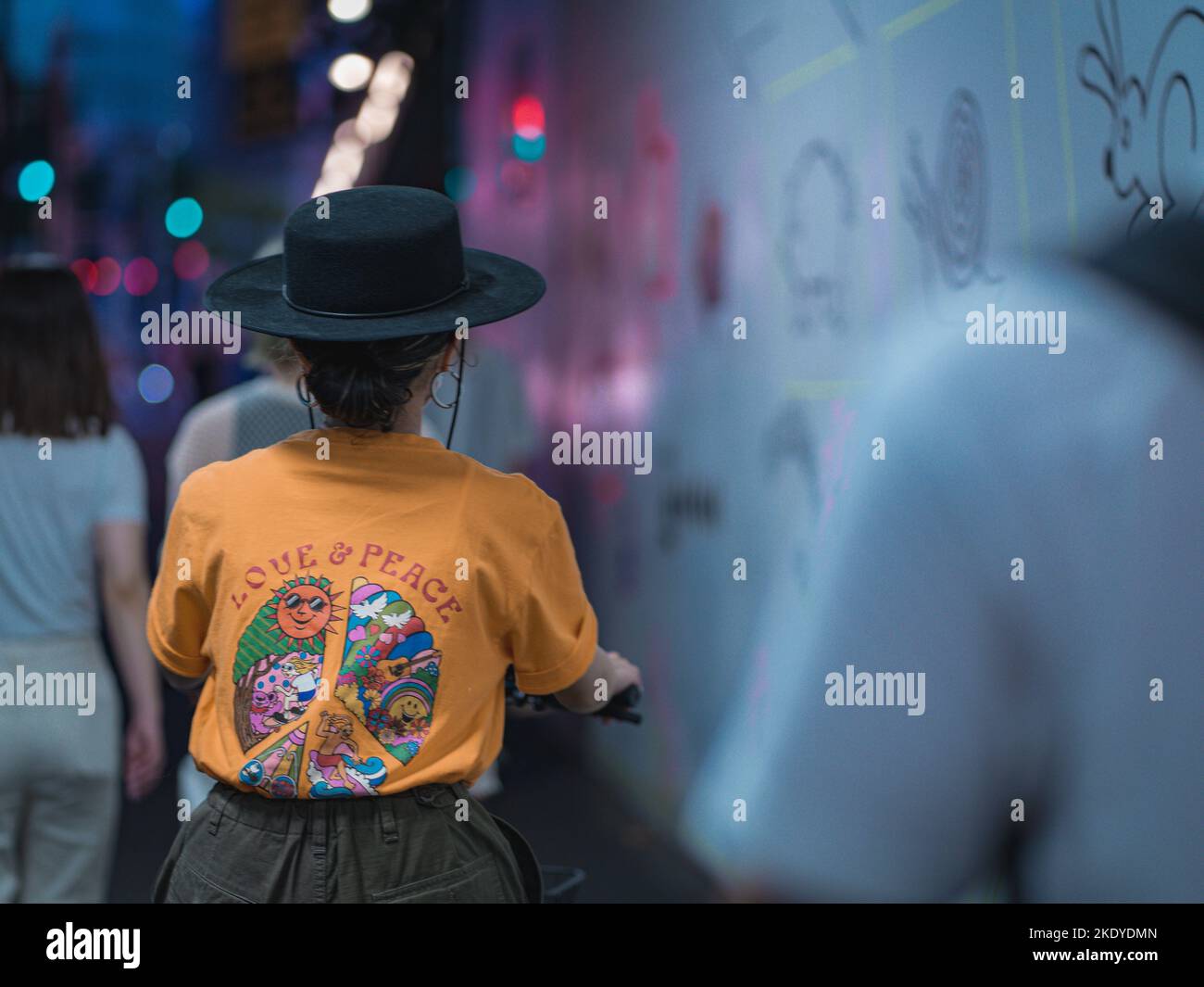 A back view of a female in a yellow shirt riding a bike Stock Photo - Alamy