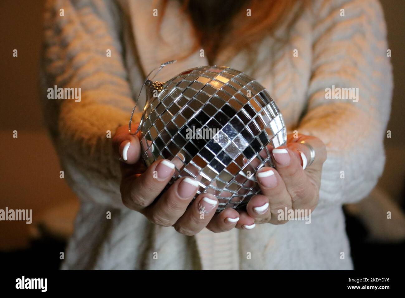 Woman's hands holding shiny ball Stock Photo - Alamy