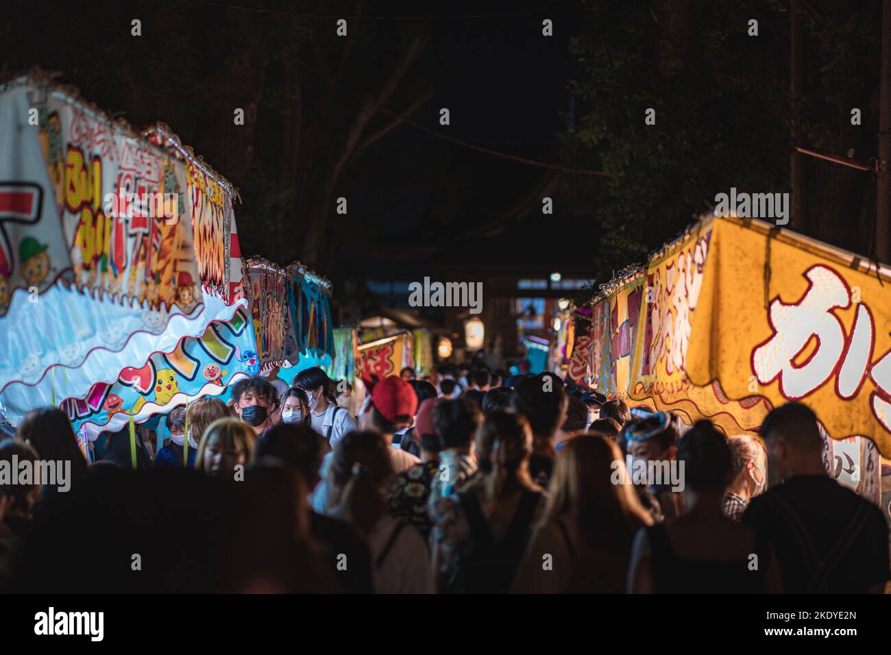A crowd of people walking around an alley with street vendors at a ...