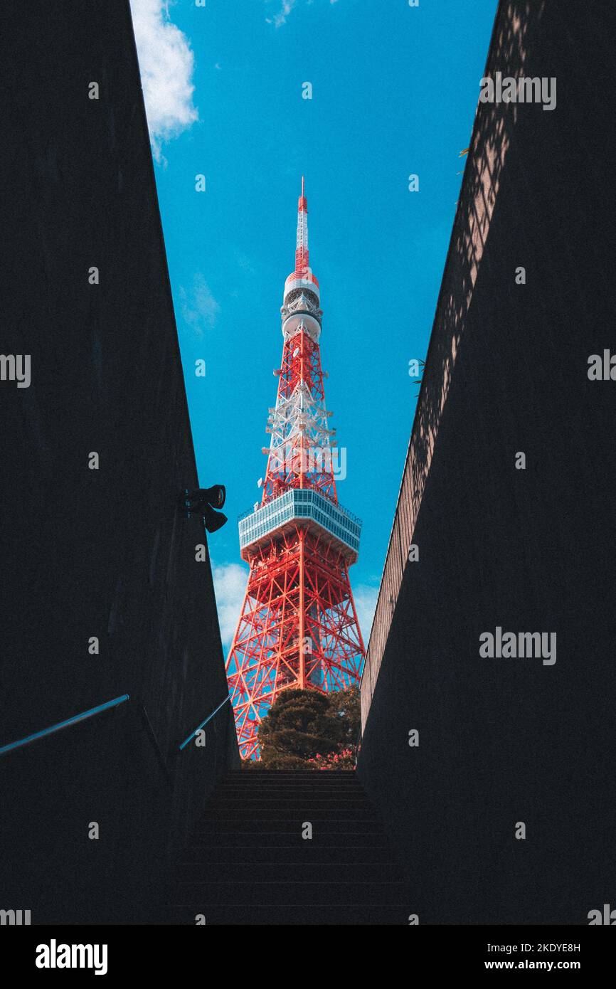 A vertical low angle shot of the red white Tokyo Tower in a blue sky in ...
