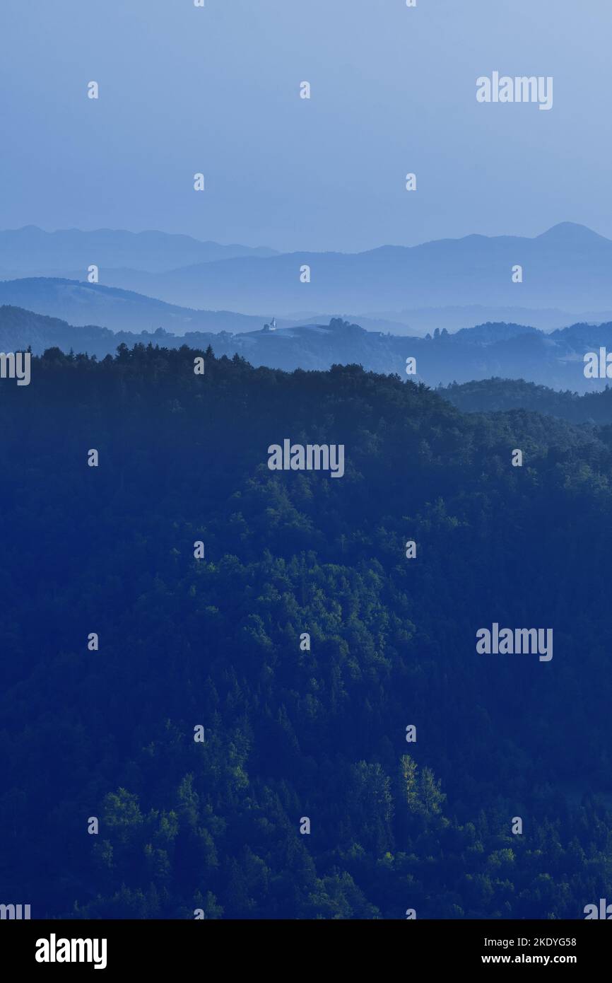 Forest covered hazy layers of hills in a beautiful moody landscape ...