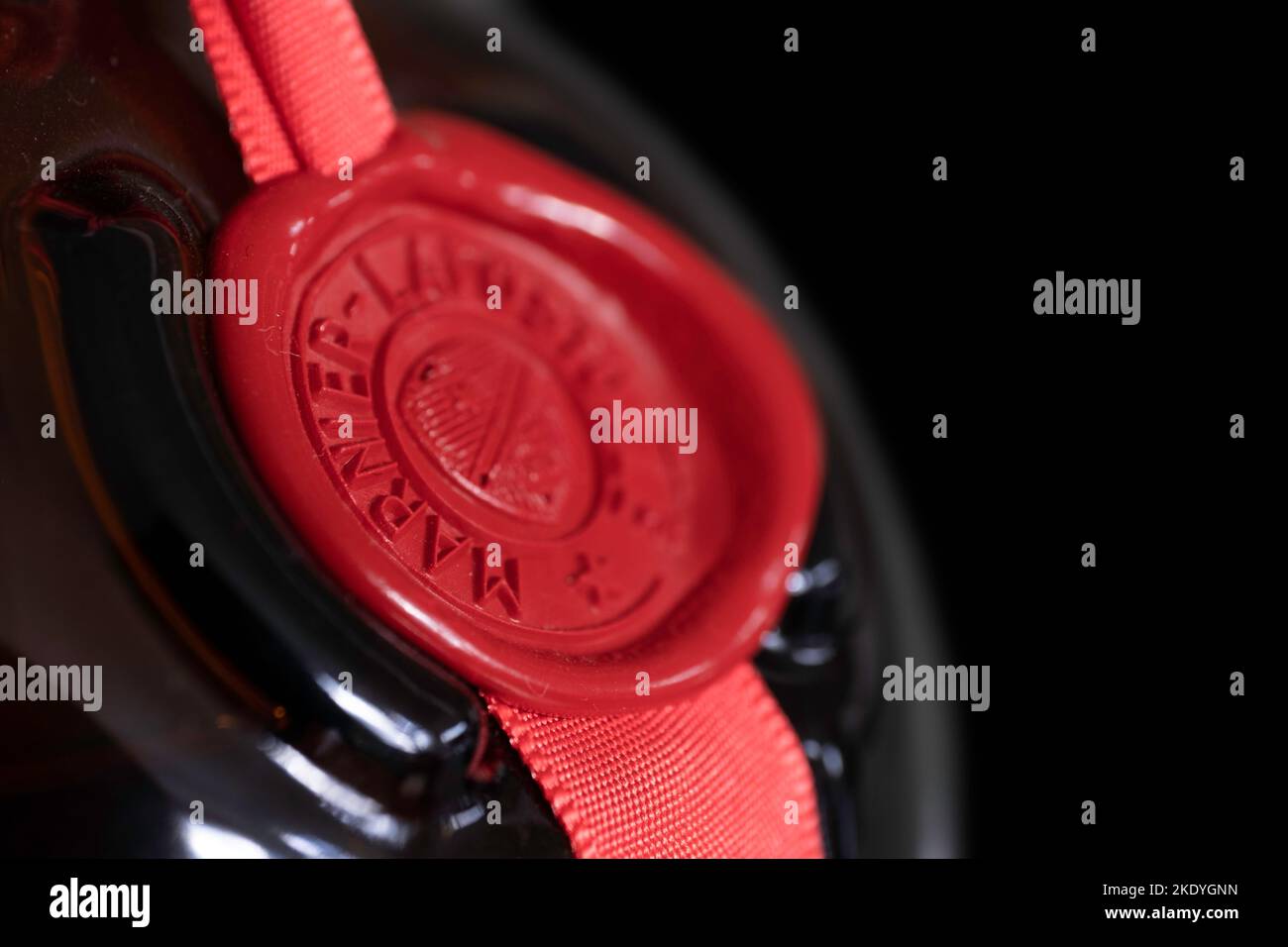 Close-up of a plastic seal with red ribbon on a bottle of Grand Marnier ...