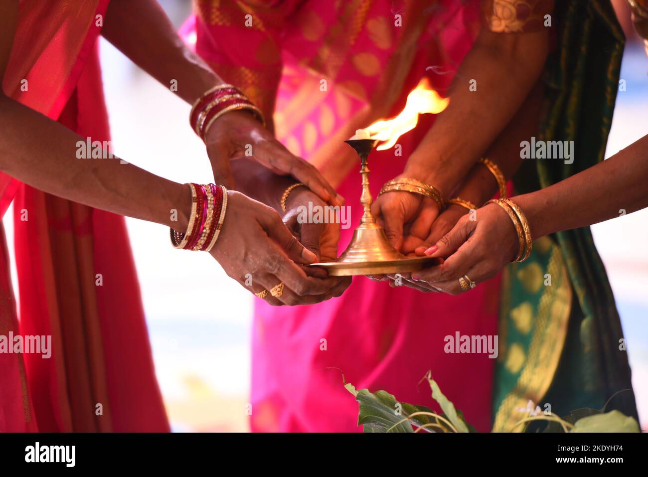 A closeup shot of people's hands holding the holy flame during a Hindu ...