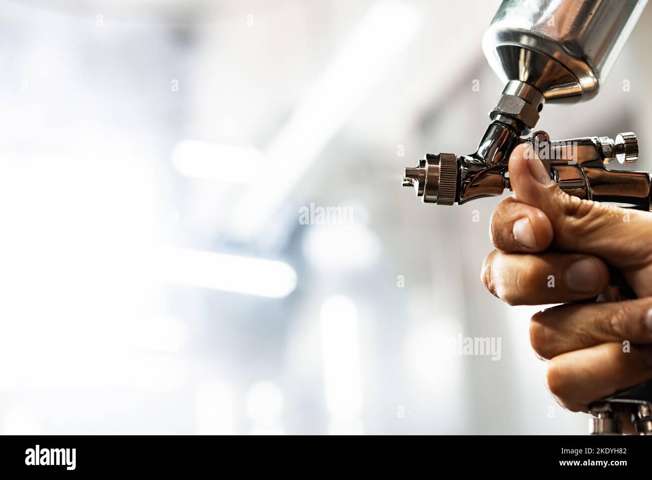Paint spray gun in the hands of a painter close up Stock Photo - Alamy