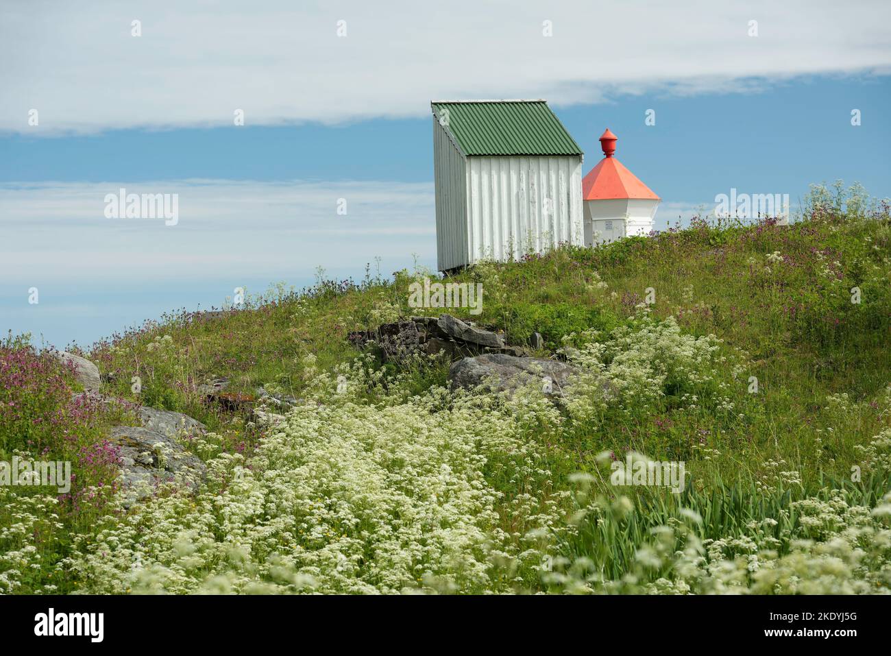 A small building with green roof in the grass with a seascape view in ...